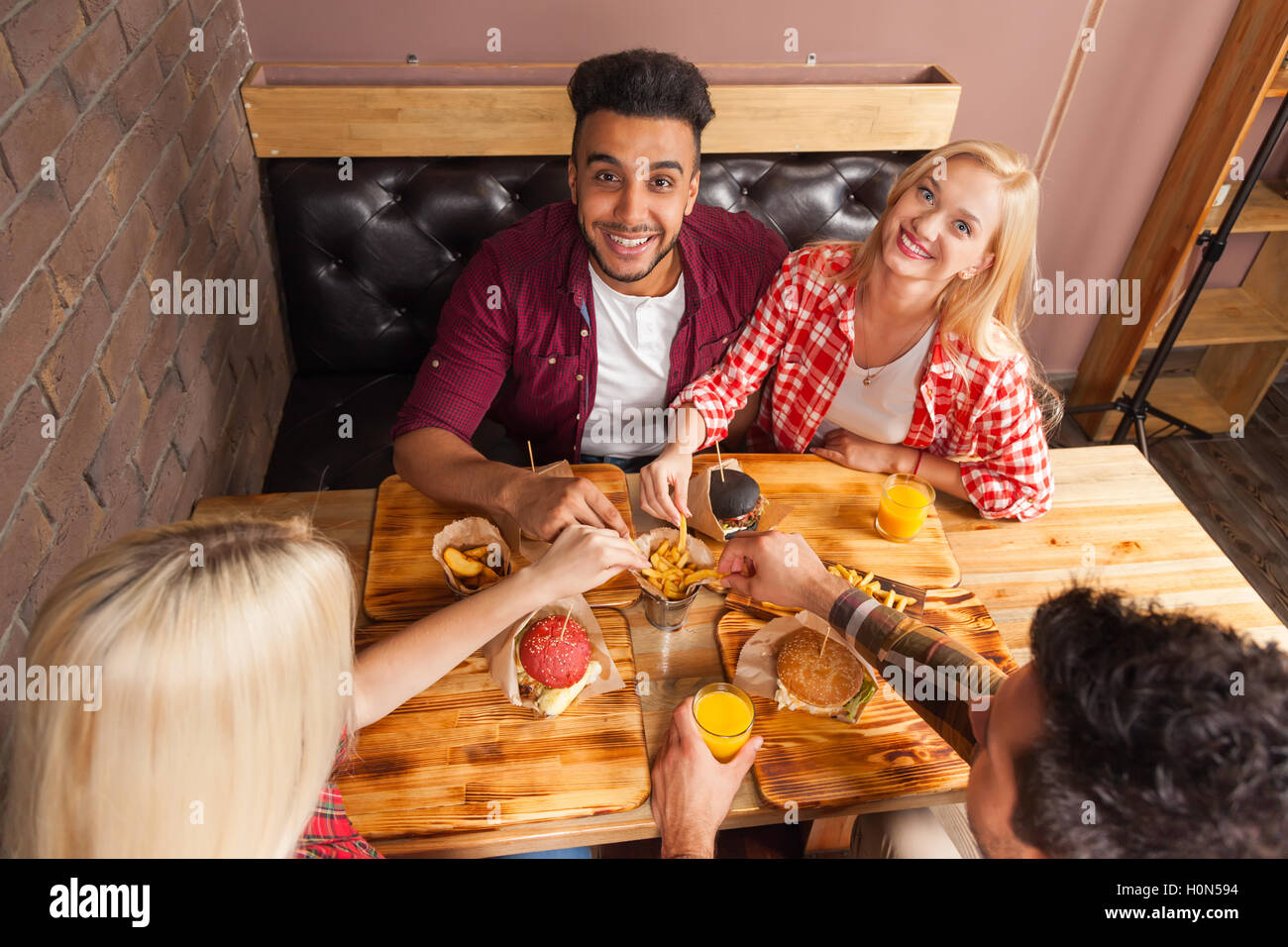 People Group Eating Fast Food Burgers Potato Sitting At Wooden Table In ...