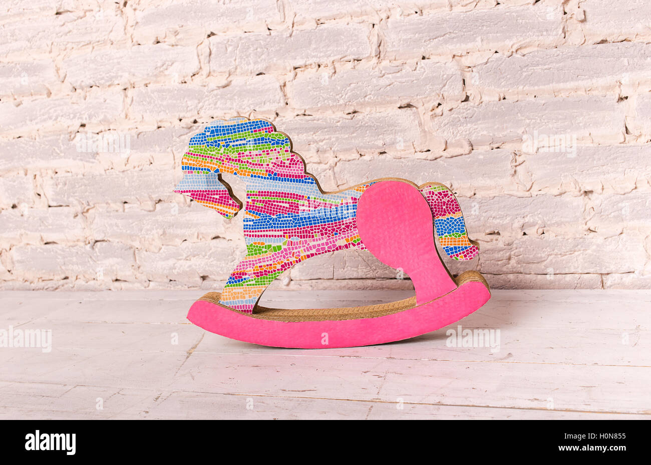 toy color rocking horse on the wooden floor in the brick wall ...