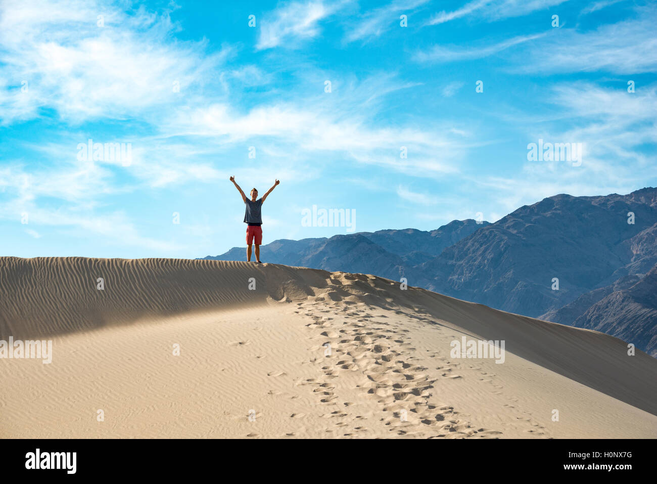 Young man standing on sand dune, Mesquite Flat Sand Dunes, Death Valley ...
