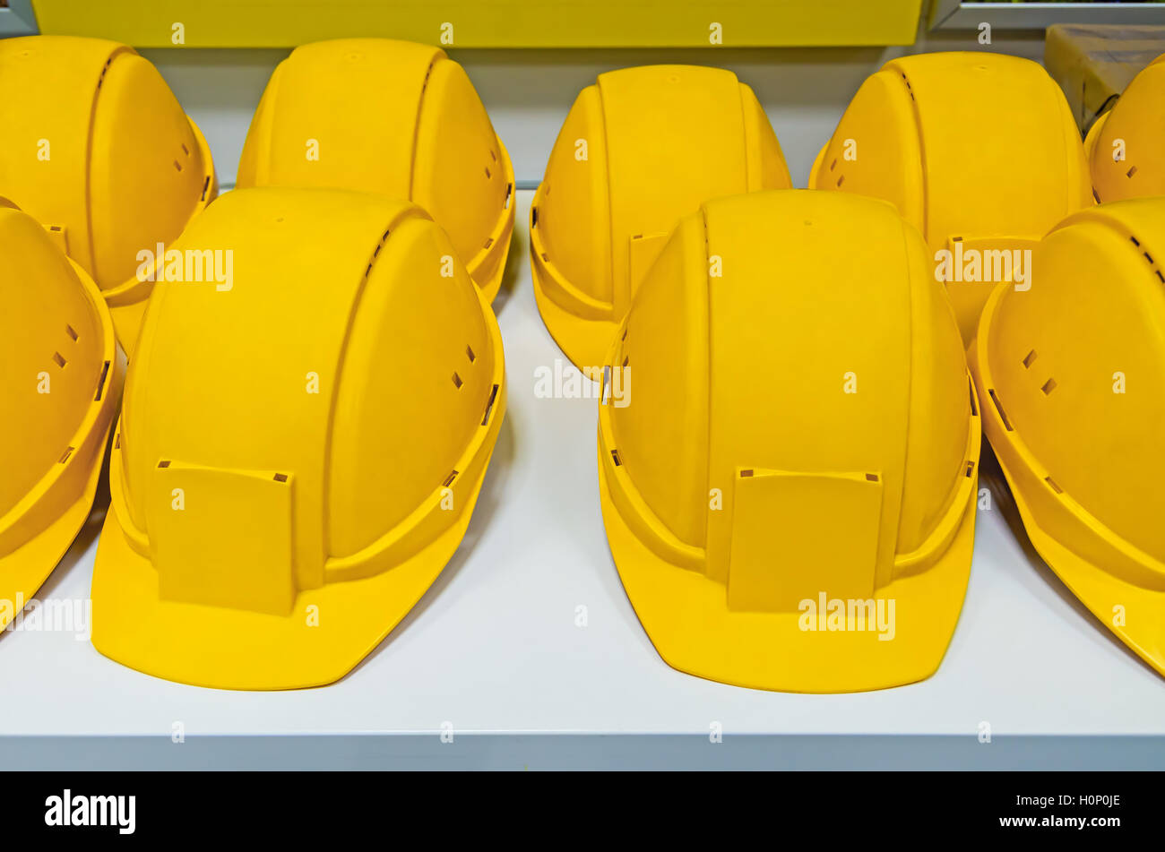Yellow protecting hard hats on bench ready for workers to pick them ...