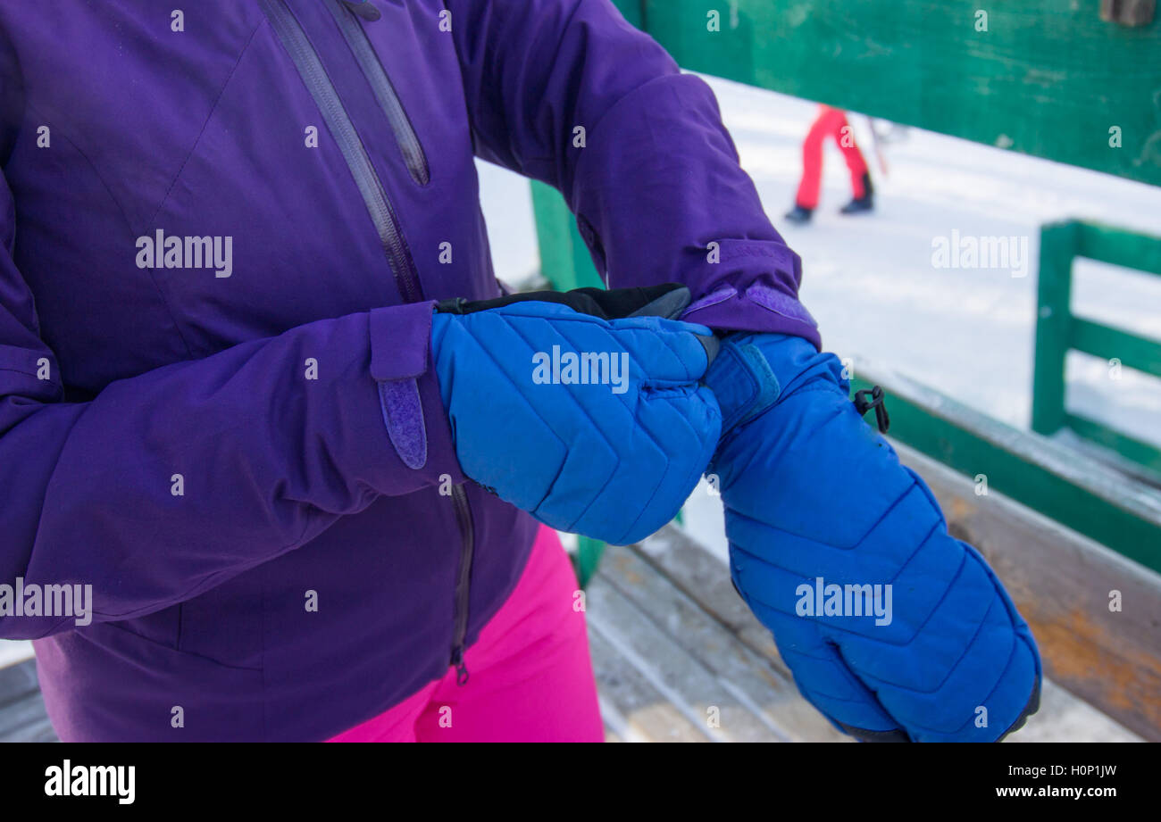 A woman in purple jacket dress blue mittens on his hands Stock Photo ...