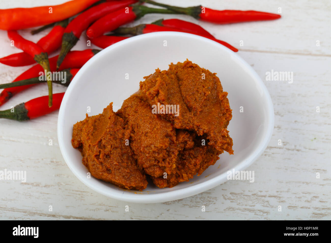 Spicy Chili paste with peppers on wood bacground Stock Photo - Alamy