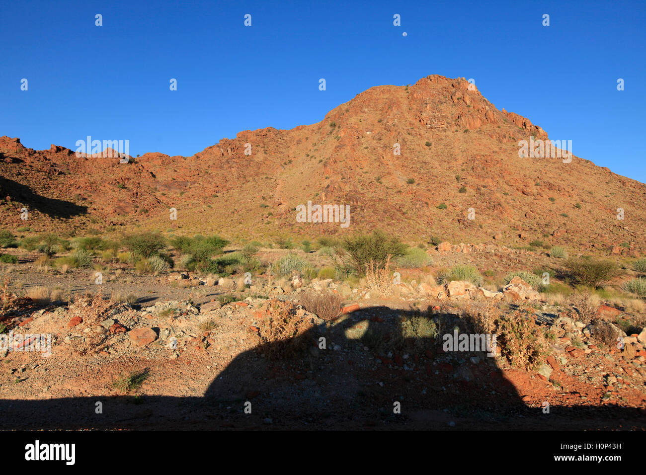 Creative roadside image of the shadow of a car agianst the a rocky ...