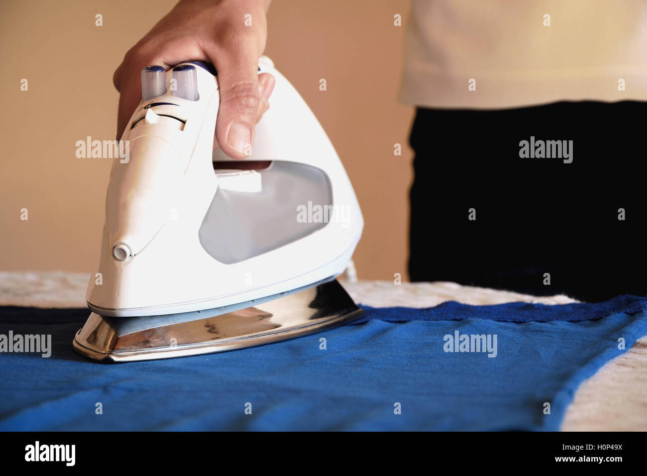 Front crop view of woman hand ironing clothes Stock Photo - Alamy