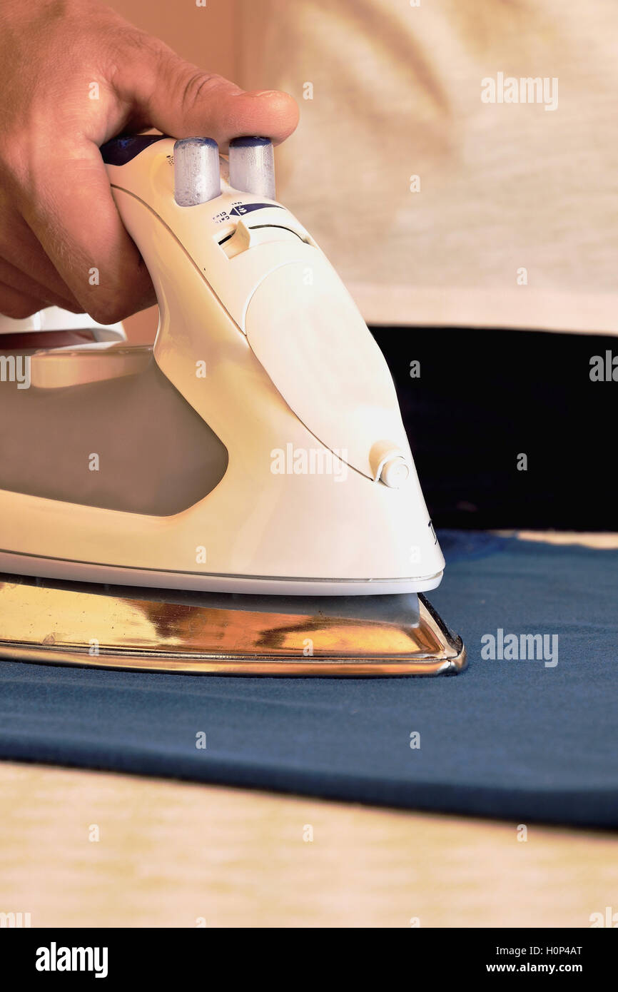 Front crop view of woman hand ironing clothes Stock Photo - Alamy