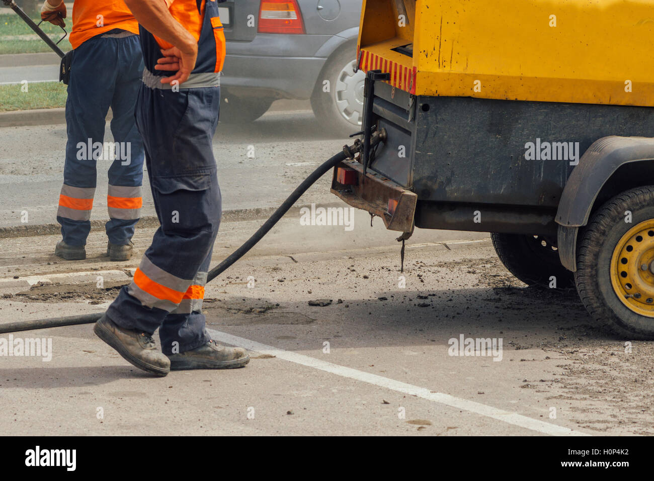 Unidentifiable road maintenance workers repairing driveway, road ...