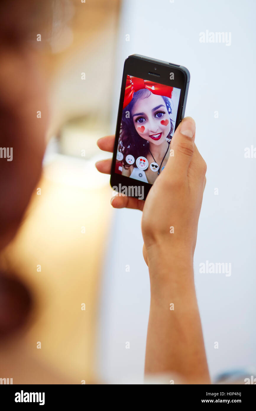 Girl using Snapchat app on her iPhone Stock Photo - Alamy