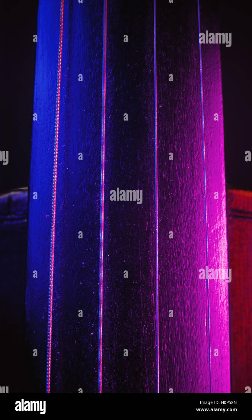 Studio composition of an old dusty violin, blue and purple illumination ...