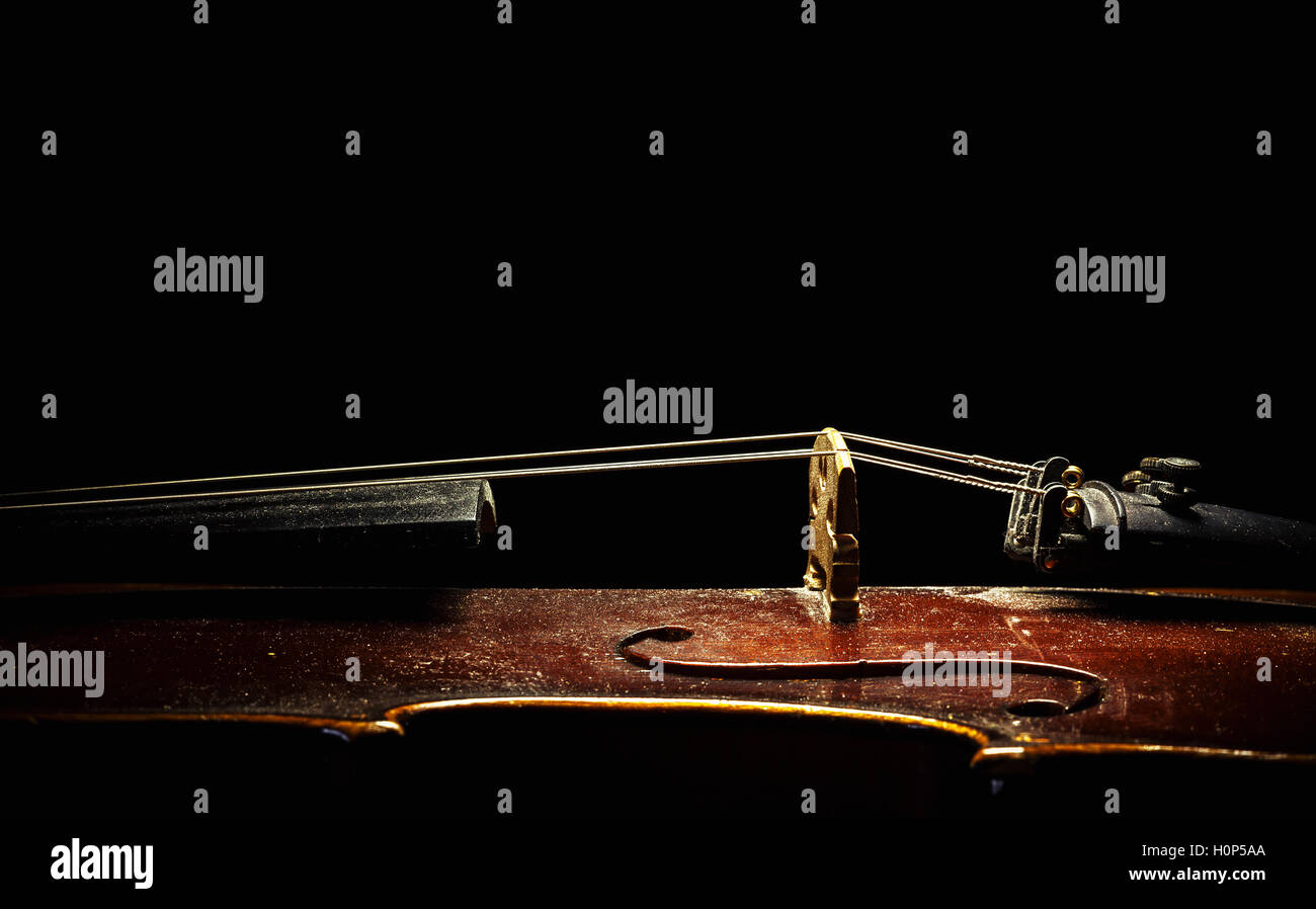 Details of an old dusty violin on black background, view from aside ...