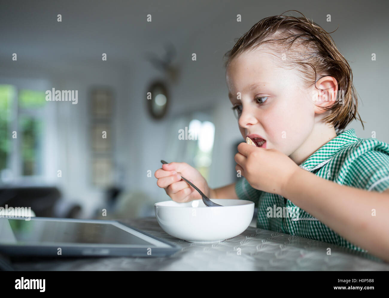 girl eating breakfast while watching the ipad Stock Photo - Alamy