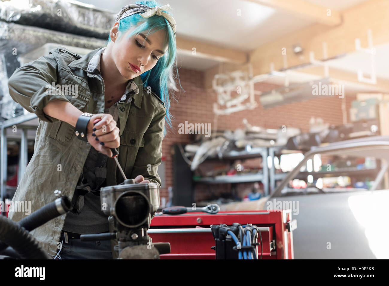 young woman mechanic repairing auto repair shop Stock Photo - Alamy