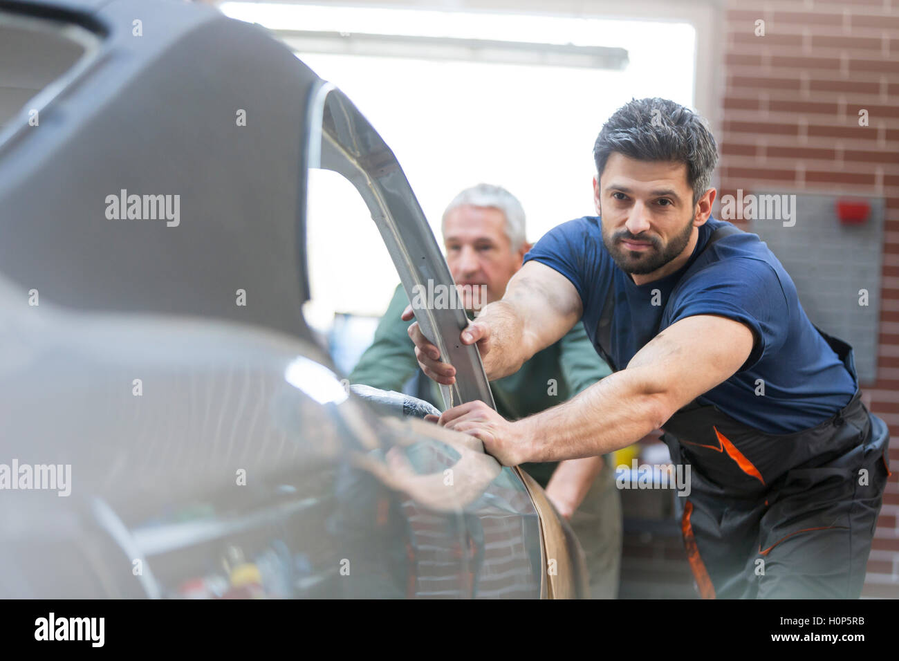 mechanic pushing car auto repair shop Stock Photo - Alamy
