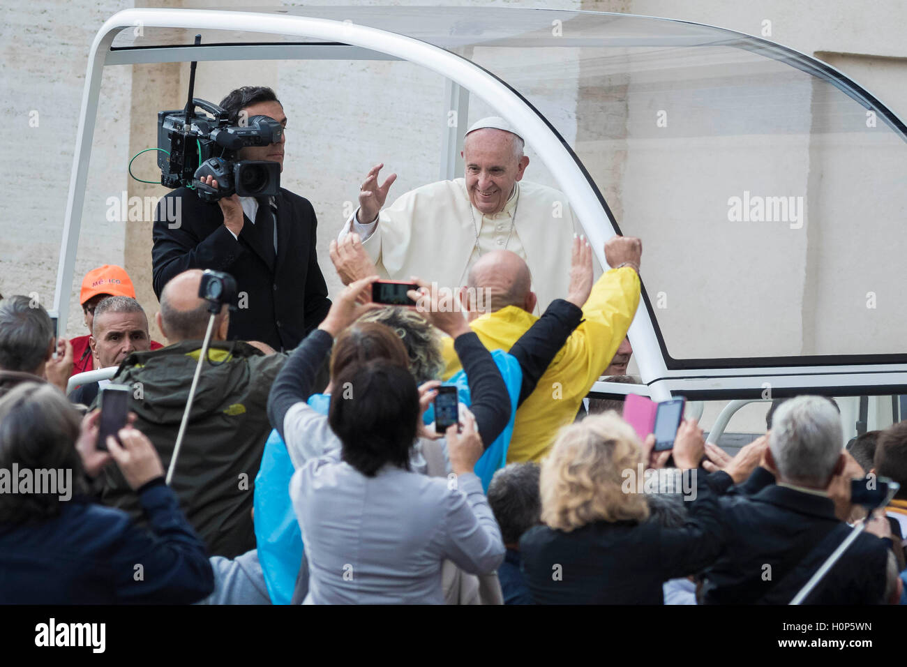 Pope Francis rides on the Popemobile through the crowd of the faithful ...