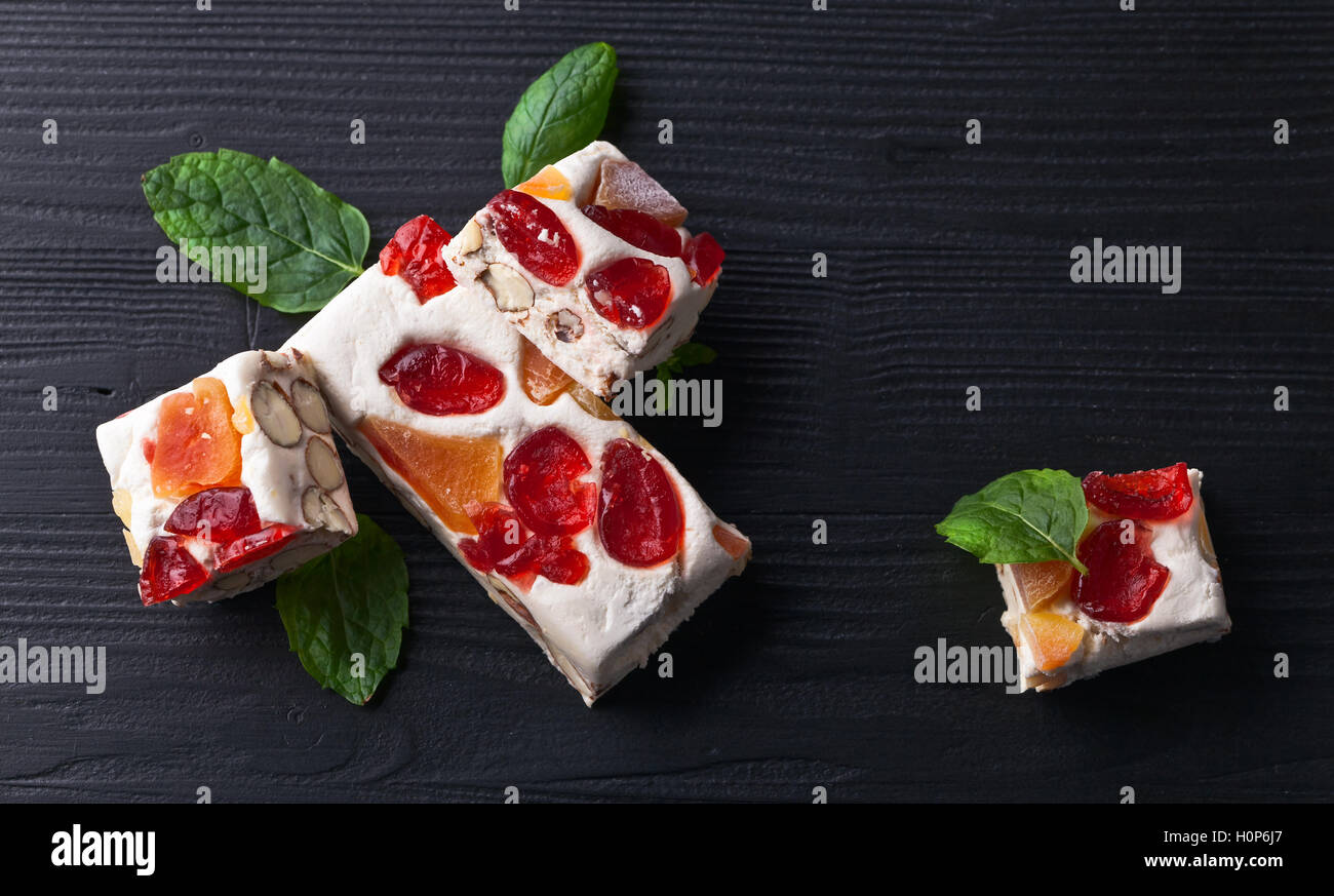 Soft nougat with tropical fruit on black table Stock Photo - Alamy