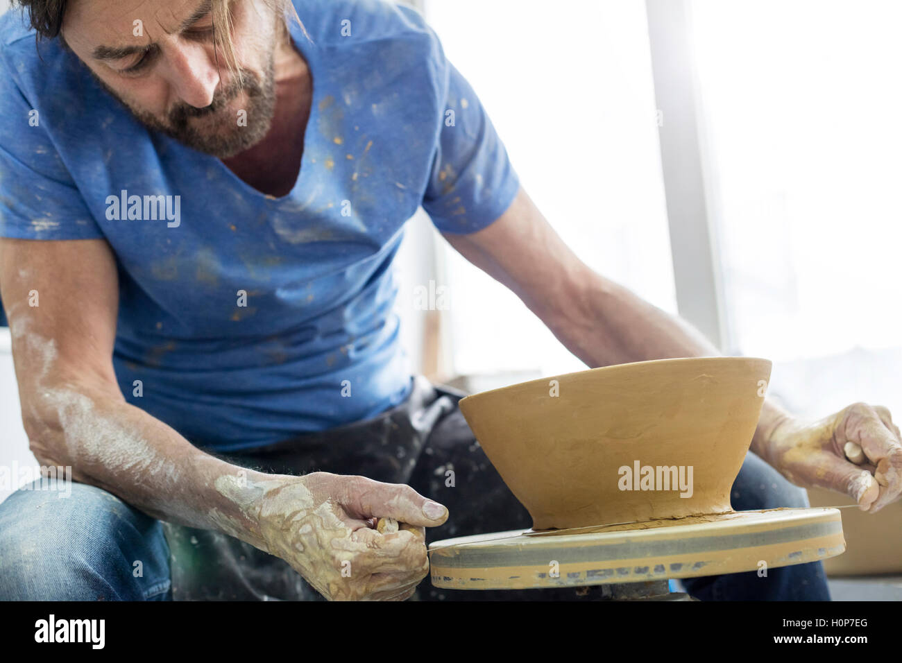 mature man using pottery wheel studio Stock Photo - Alamy