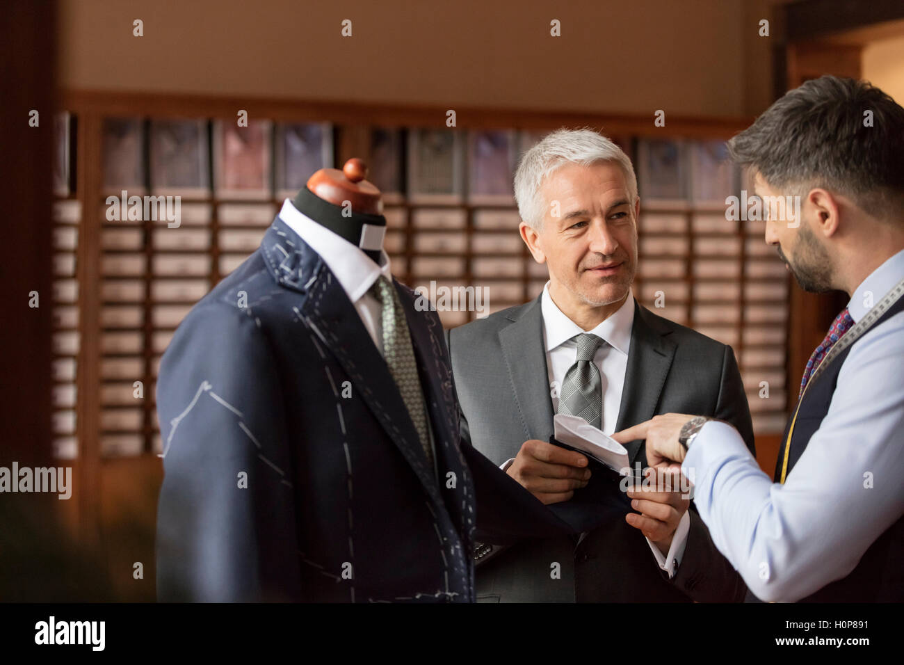 tailor explaining suit businessman menswear shop Stock Photo - Alamy