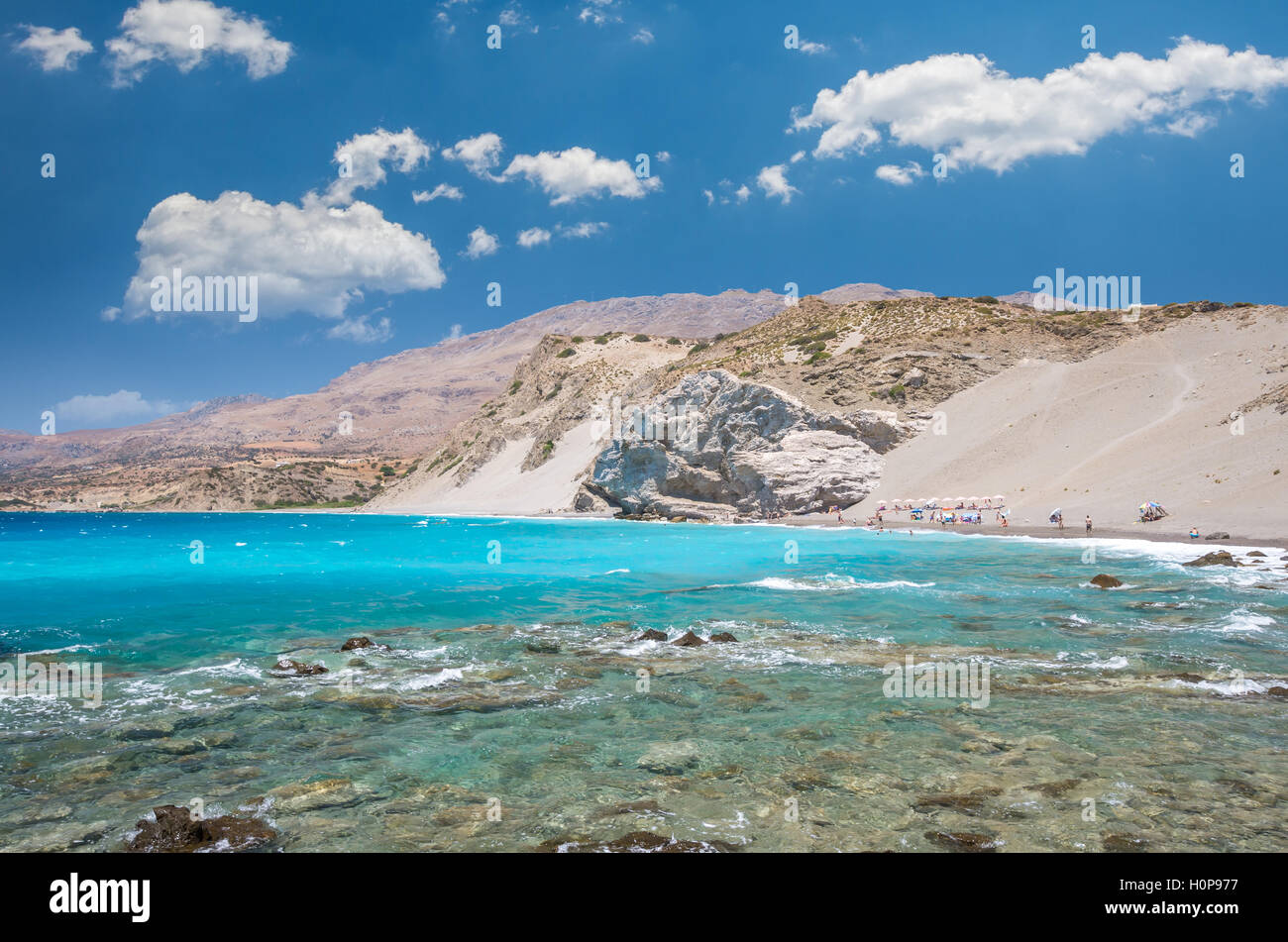 Agios Pavlos Beach in Crete island, Greece. Tourists relax and bath in crystal clear water of St ...