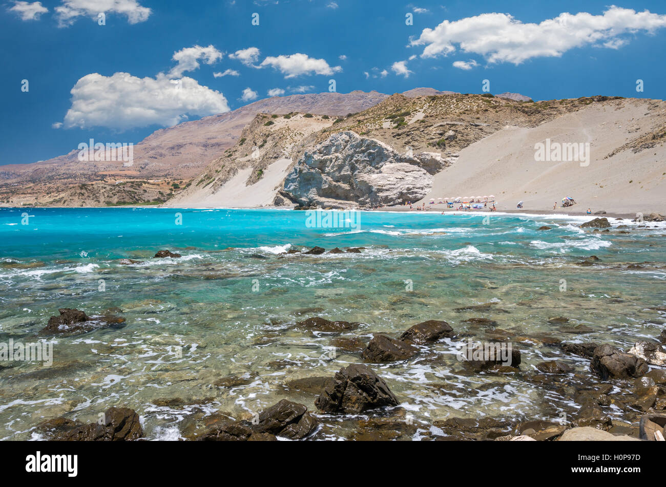 Agios Pavlos Beach in Crete island, Greece. Tourists relax and bath in crystal clear water of St ...