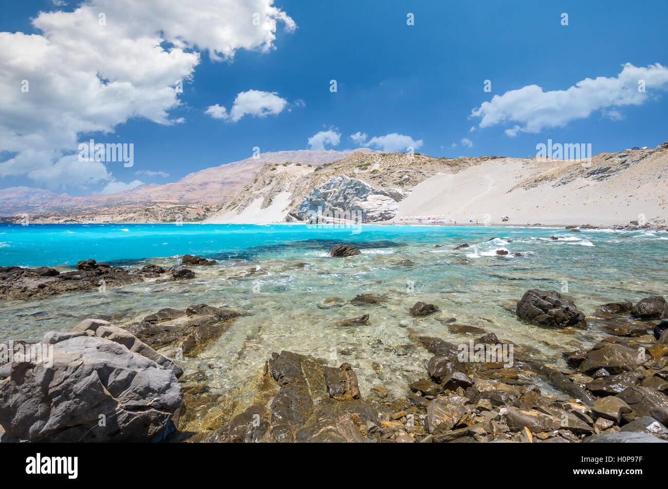 Agios Pavlos Beach in Crete island, Greece. Tourists relax and bath in crystal clear water of St ...