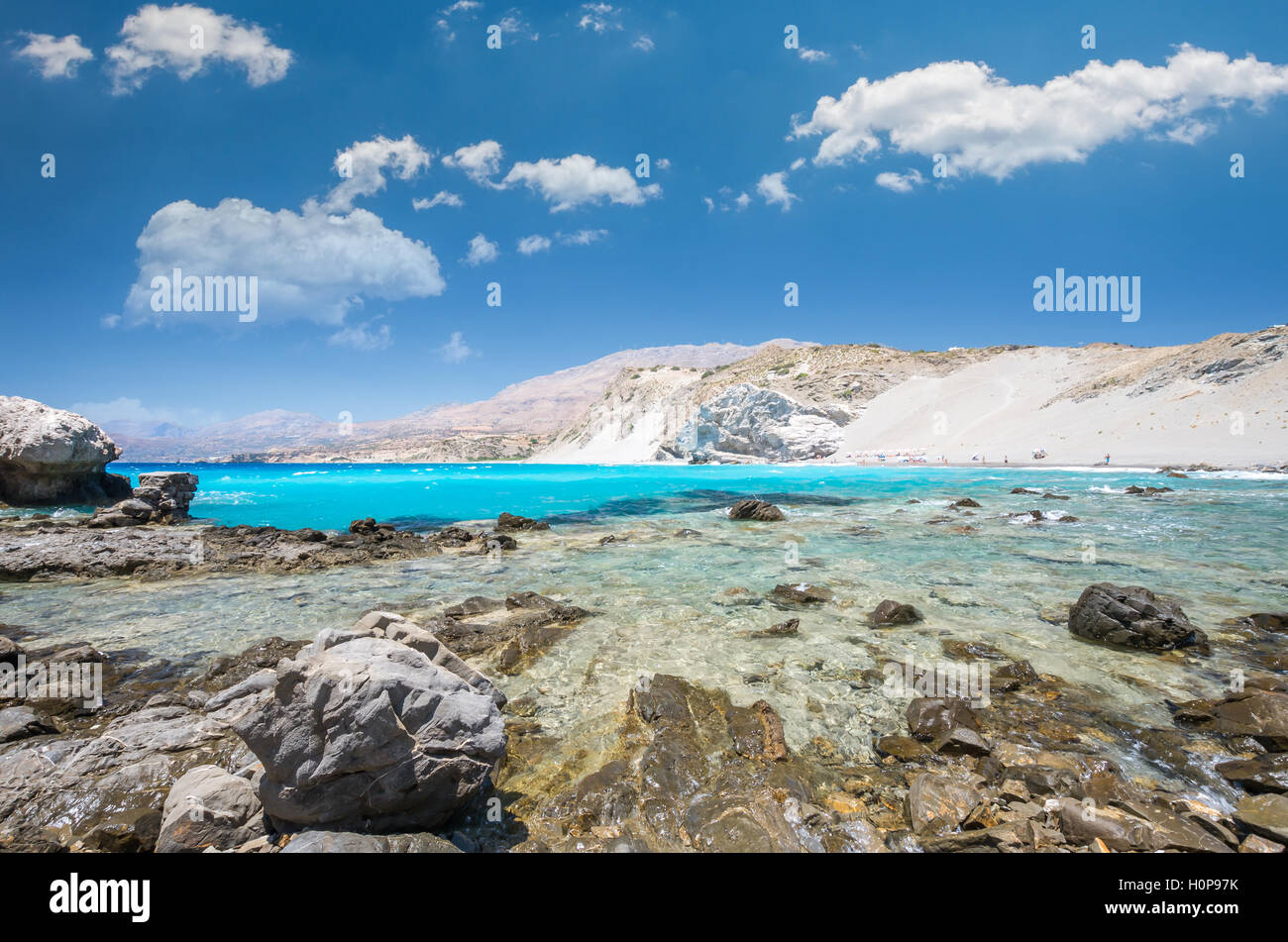 Agios Pavlos Beach in Crete island, Greece. Tourists relax and bath in crystal clear water of St ...