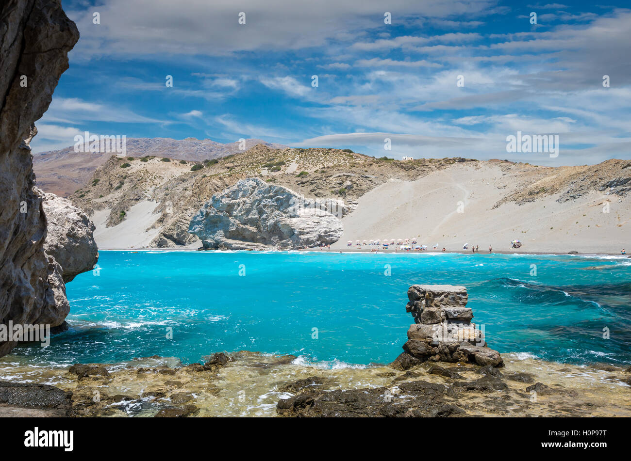 Agios Pavlos Beach in Crete island, Greece. Tourists relax and bath in crystal clear water of St ...