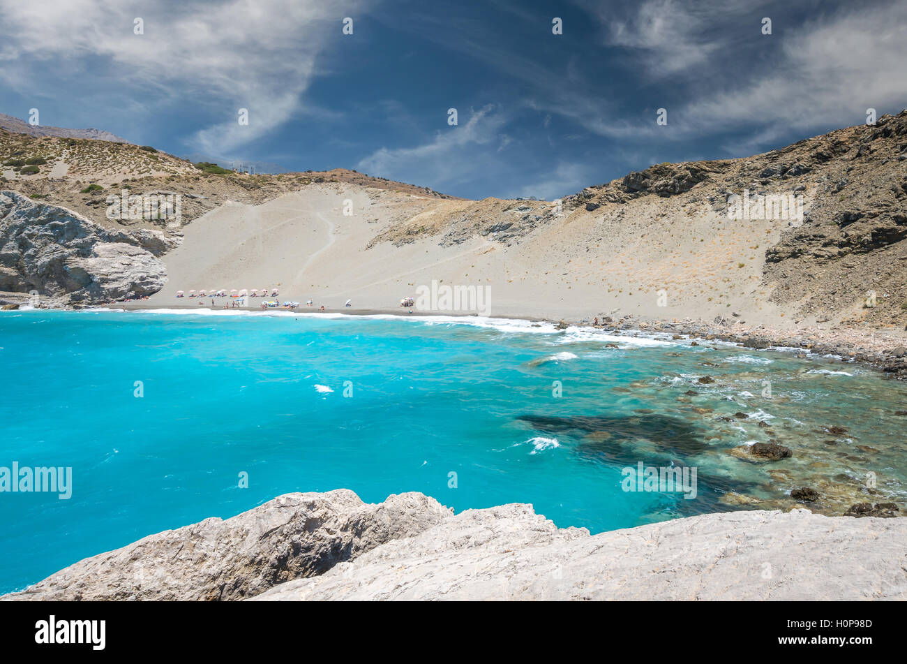 Agios Pavlos Beach in Crete island, Greece. Tourists relax and bath in crystal clear water of St ...