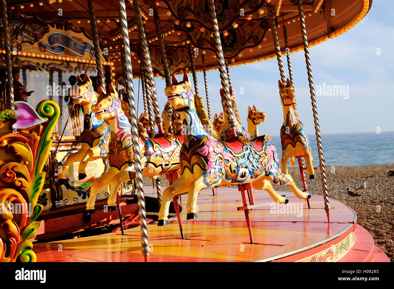 An old style roundabout with galloping horses on a beach front Stock ...