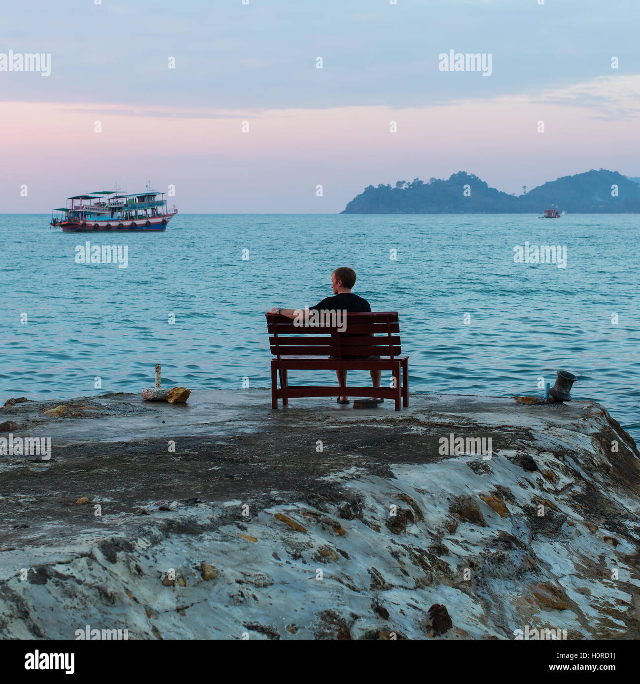 Man at the beach sitting on a bench hi-res stock photography and images ...