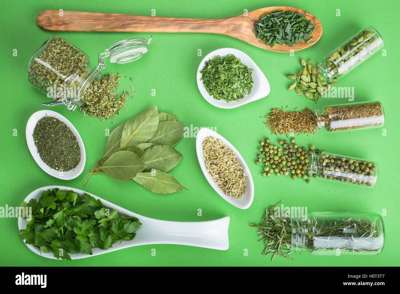 Assortment of green herbs and spices on a green background Stock Photo ...
