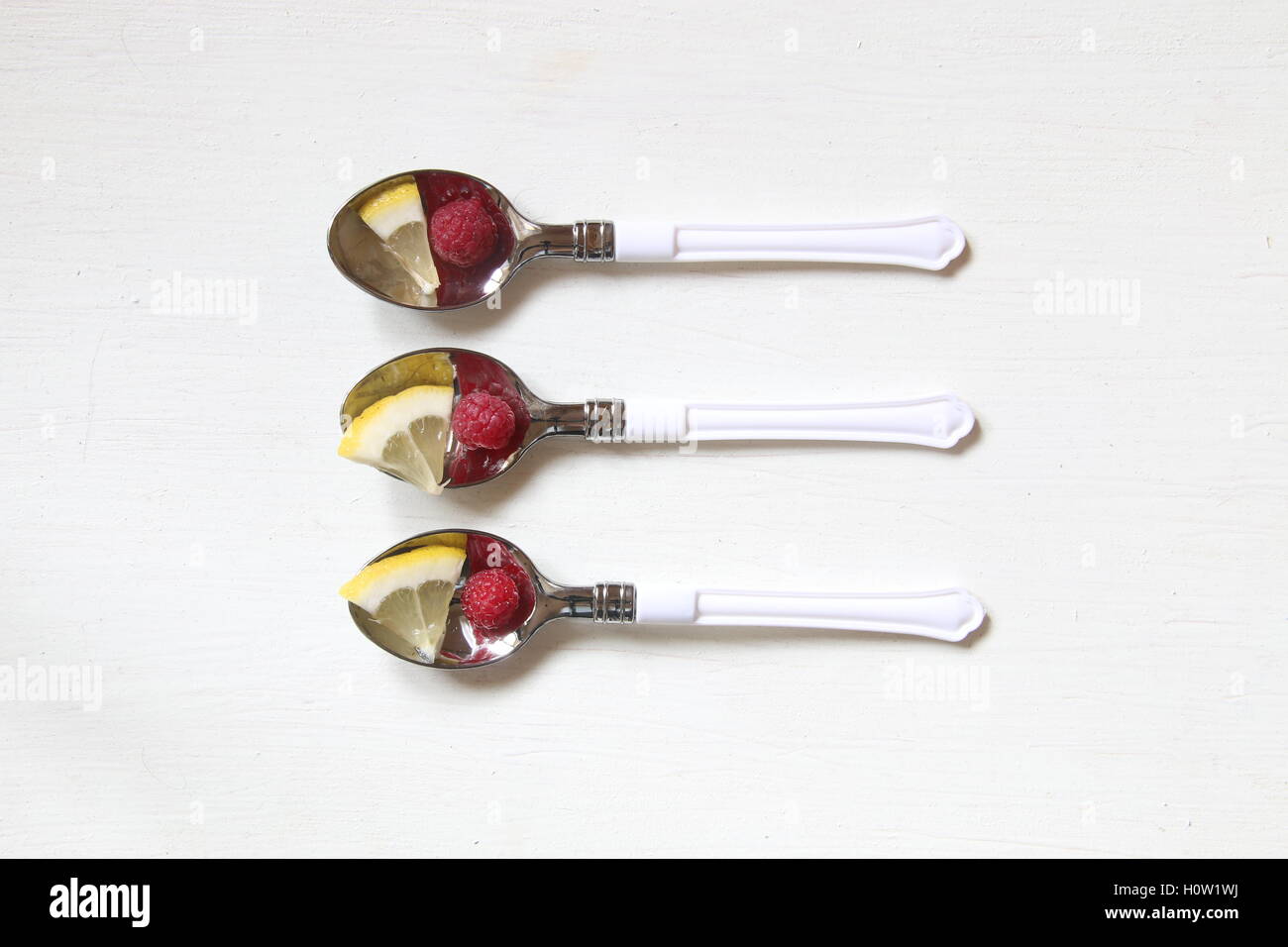 Healthy food idea, spoon with lemon and raspberrieson Stock Photo - Alamy