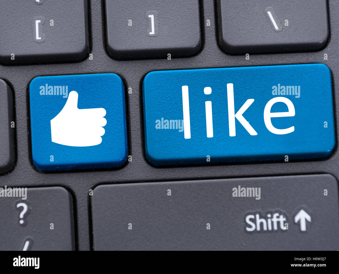 Keyboard with blue like button icon in close up as social media concept ...