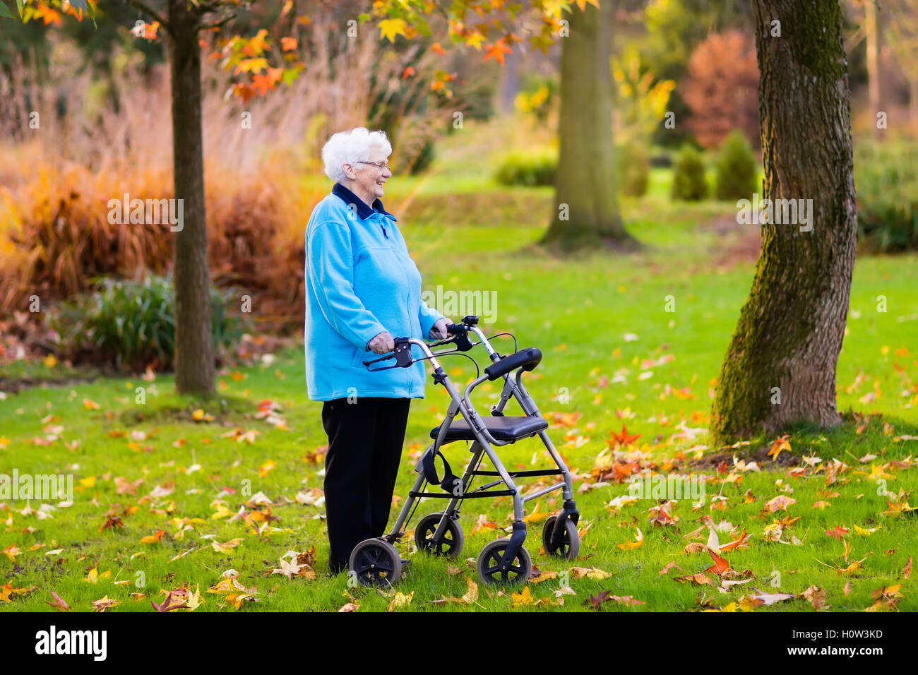 Happy senior handicapped lady with a walking disability enjoying a walk ...