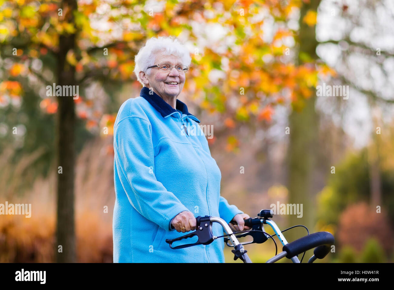 Happy senior handicapped lady with a walking disability enjoying a walk ...