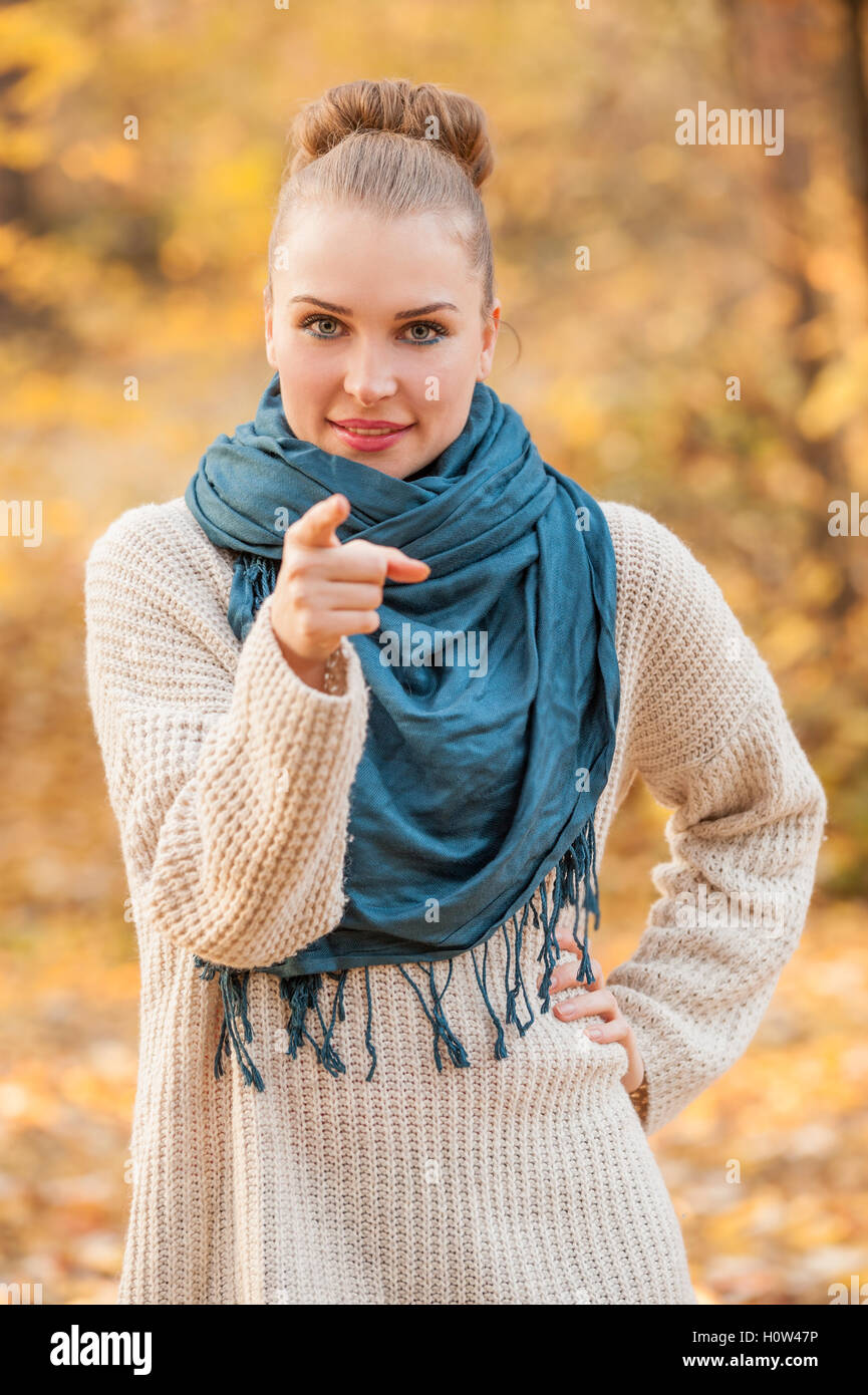 Attractive trendy woman pointing at you while standing outside in ...