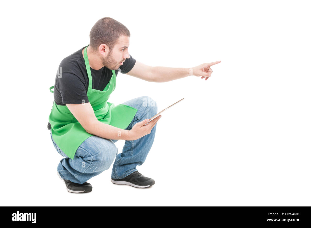 Supermarket young employee pointing something holding tablet isolated ...