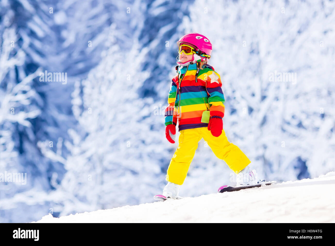 Child skiing in mountains. Active toddler kid with safety helmet ...