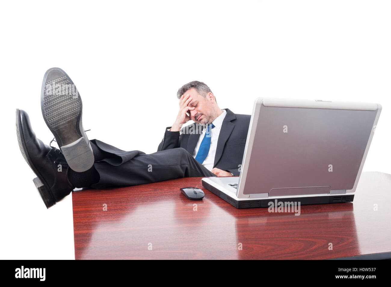 Businessman taking a nap with his feet up on computer desk in office on ...