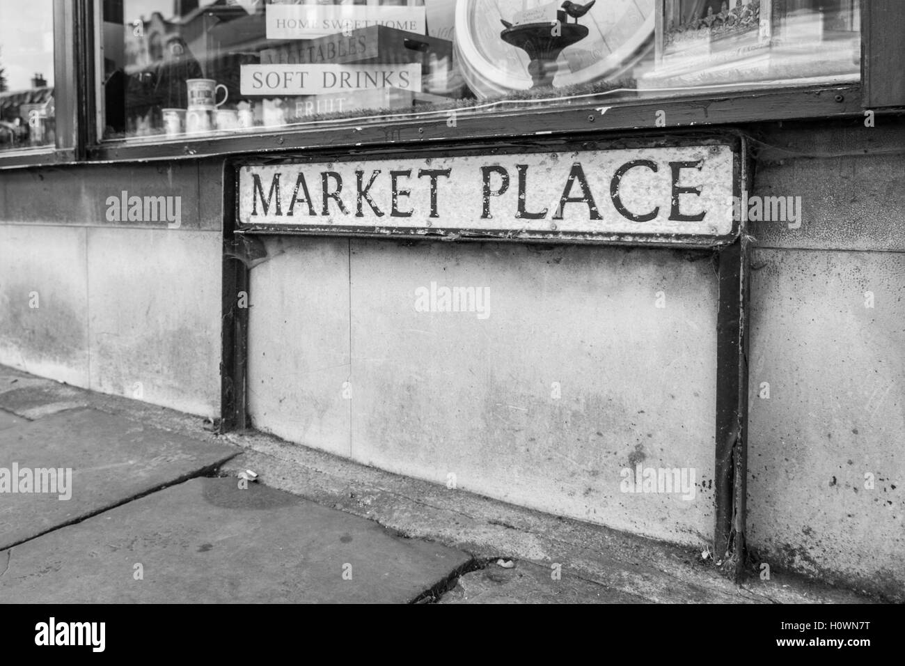 Aged street sign showing the name "Market Place" on a street corner in ...
