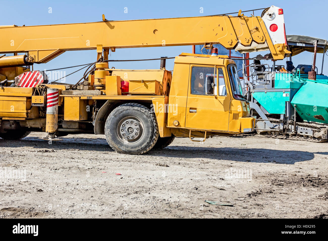Rusty old mobile crane is parked at construction site. Landscape ...