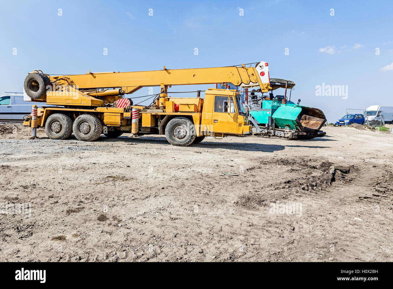 Rusty old mobile crane is parked at construction site. Landscape ...