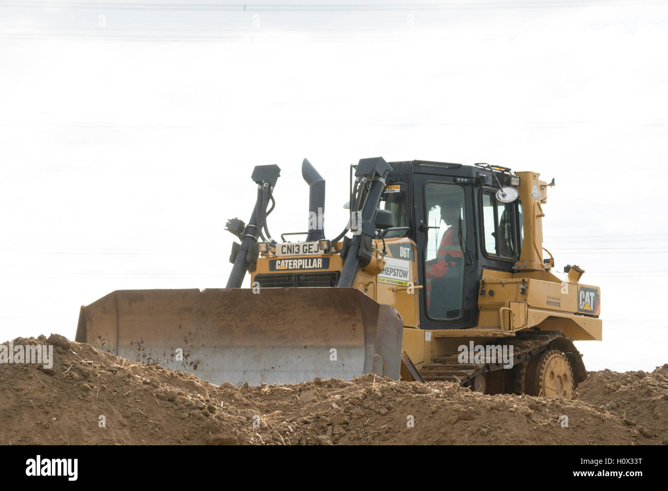 Bulldozer pushing mud over to create a wall around a new mine. With ...