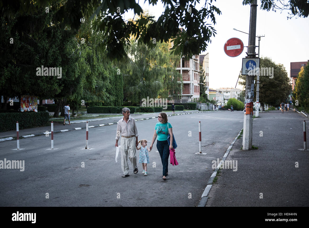 A couple with their daughter walk at the center of the town of ...