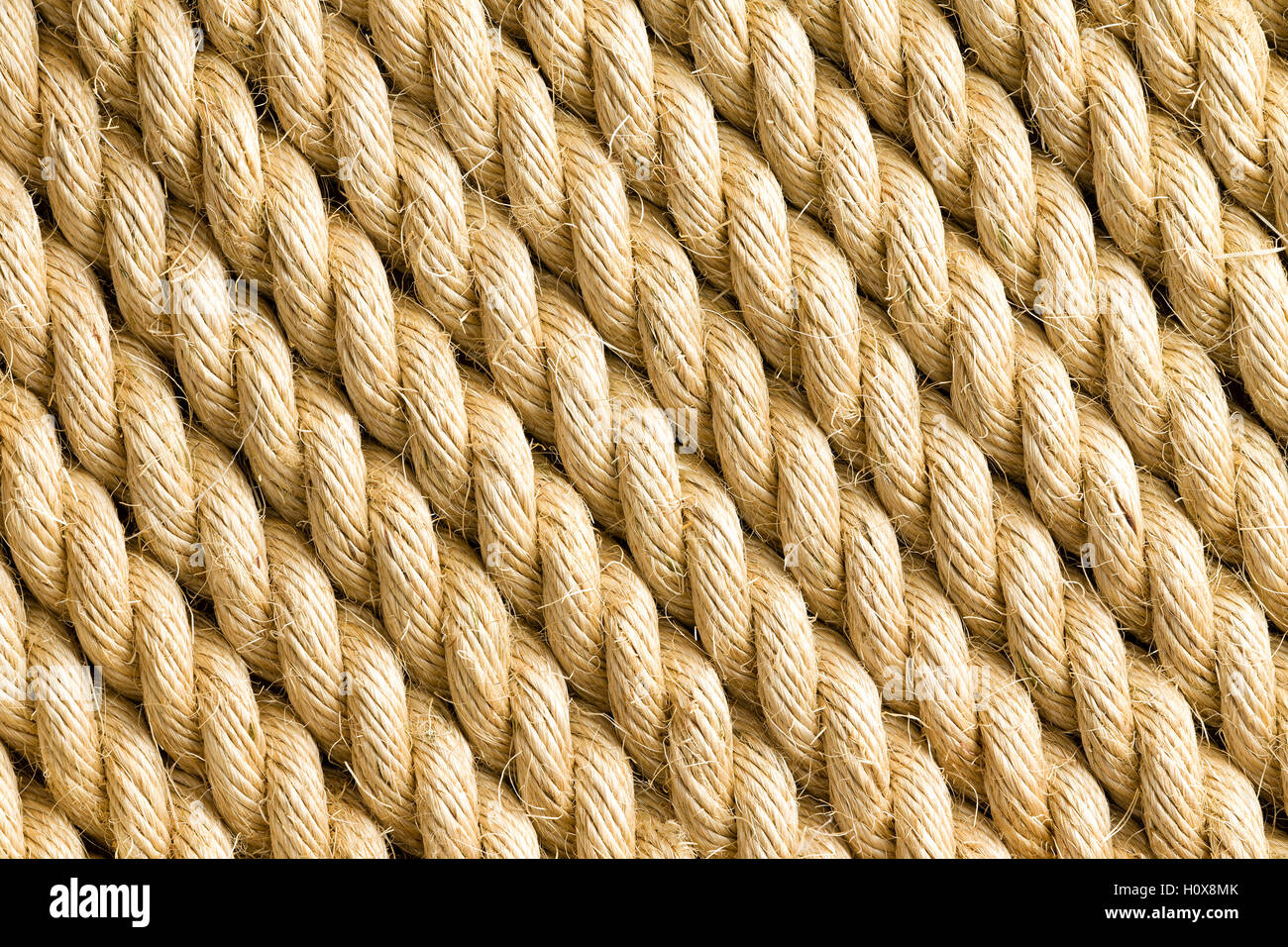Diagonal strands of thick yellow rope as background with copy space for ...