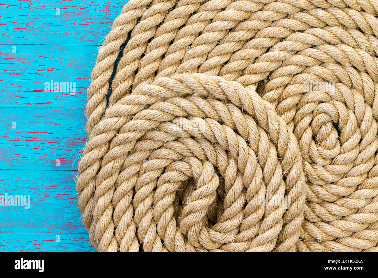 Maritime theme background of wound up rope over worn out blue painted ...