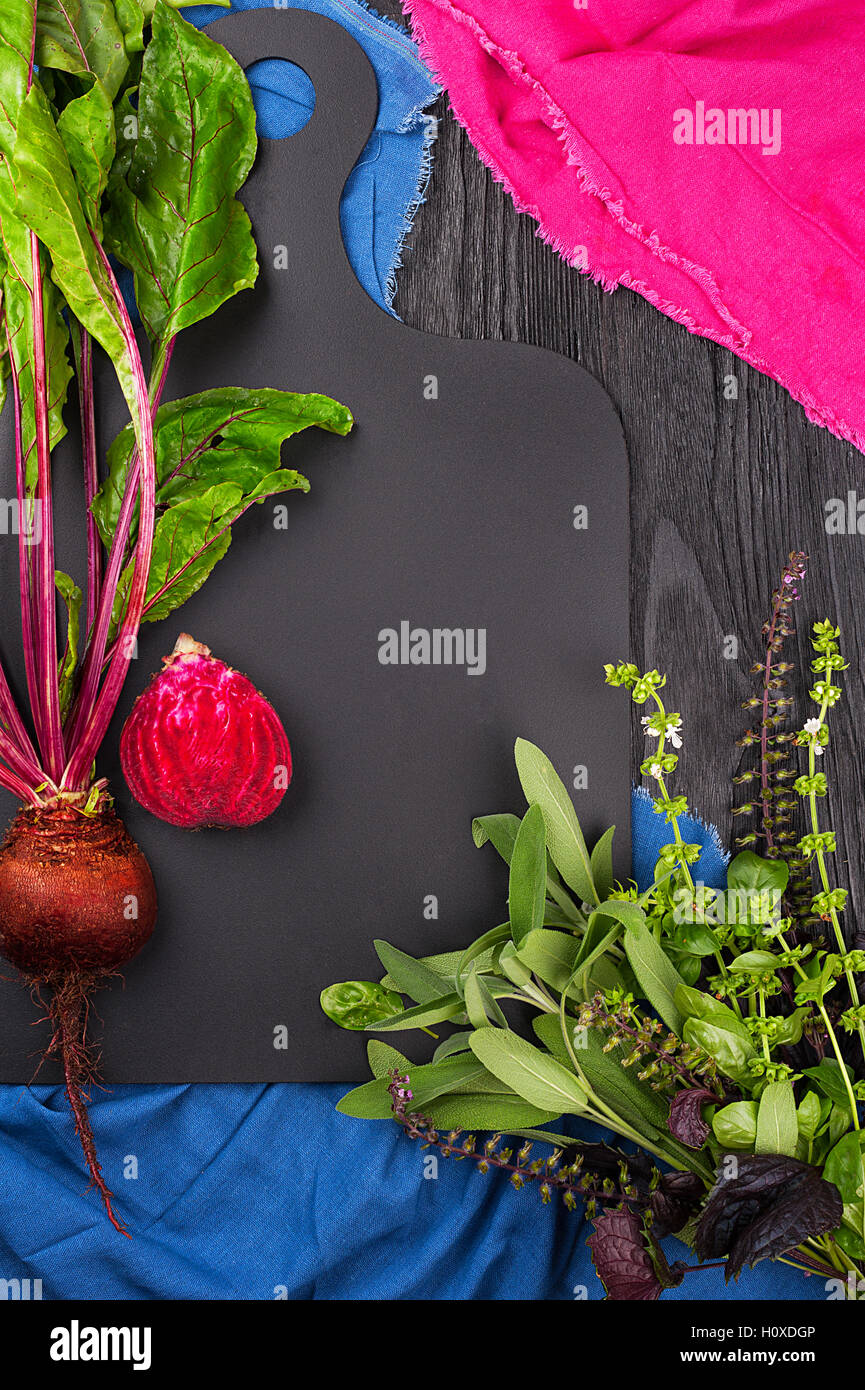 Cut beets and a bouquet of herb on a blackboard top view with copy ...