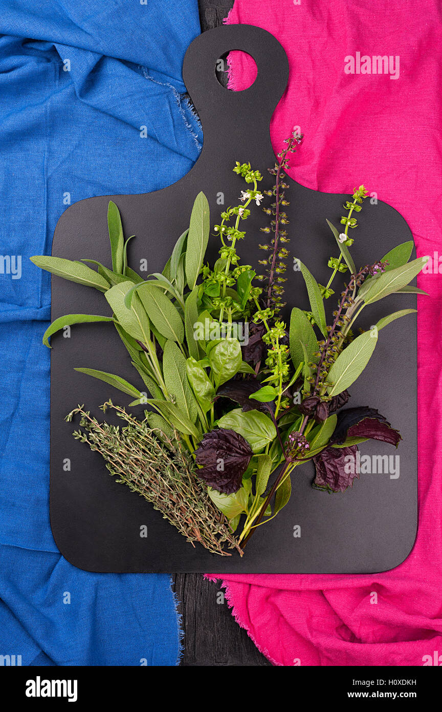 Bouquet of spices of sage, basil, thyme on a blackboard top view with ...
