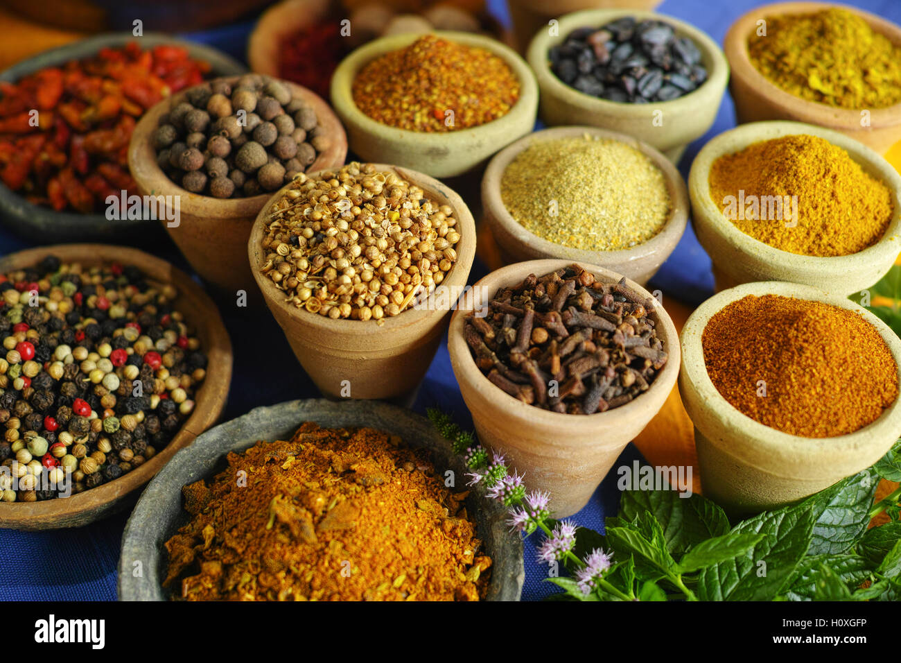 Collection of different spices in old clay bowls in colorful oriental ...