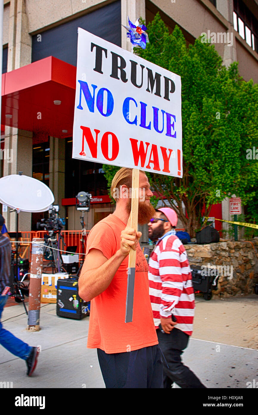 Man holding an anti-Donald Trump banner at a Donald Trump convention in ...