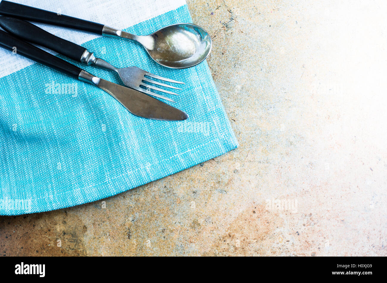 Rustic table setting with vintage silverware and plates on stone table ...