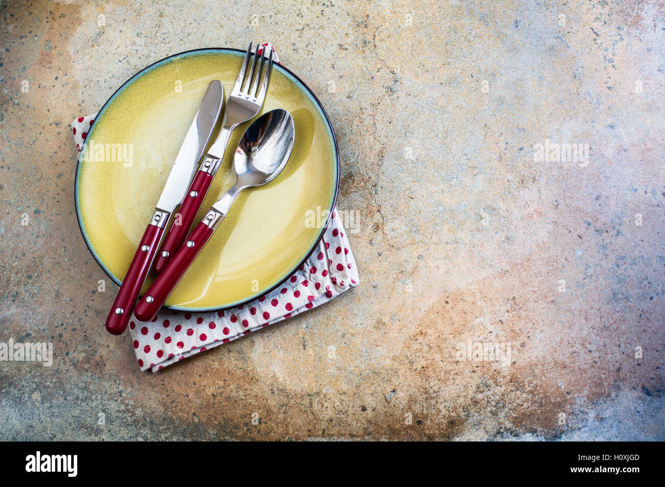 Rustic table setting with vintage silverware and plates on stone table ...
